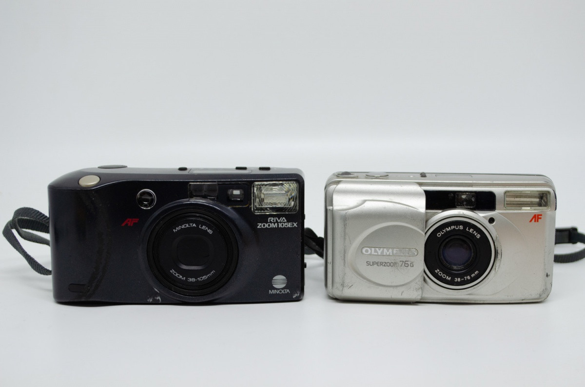 02 Câmeras fotográficas sendo Olympus Superzoom 76g e M
